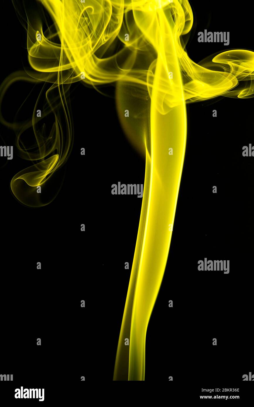 Abstract shape of yellow smoke on black background Stock Photo - Alamy