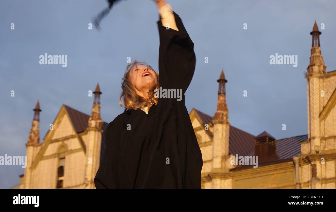 Graduation - girl throws her hat in the air and smiles to camera Stock ...