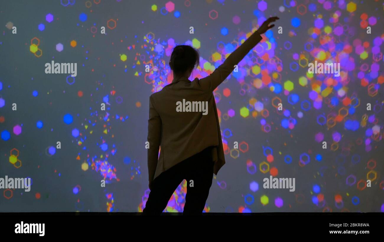 Large screen augmented reality experience - woman moving hands in front ...