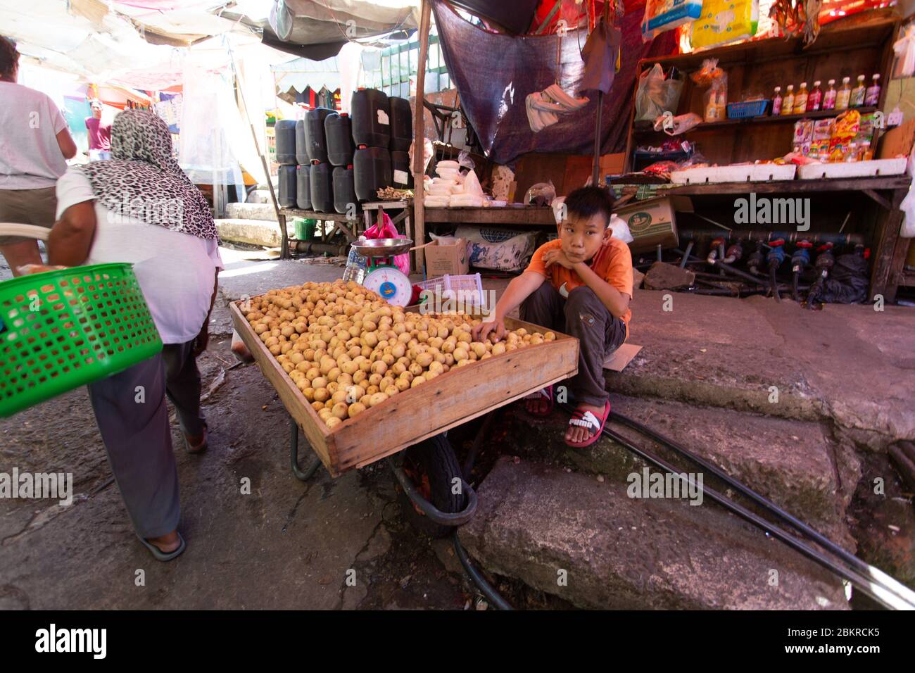 Semporna, Sabah, Malaysia - 26 April 2020 - a young boy selling lansium ...