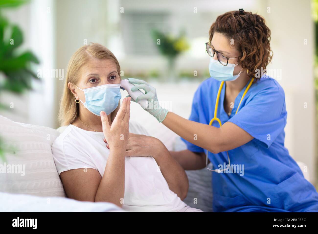 Doctor examining sick patient in face mask. Ill woman in health clinic ...