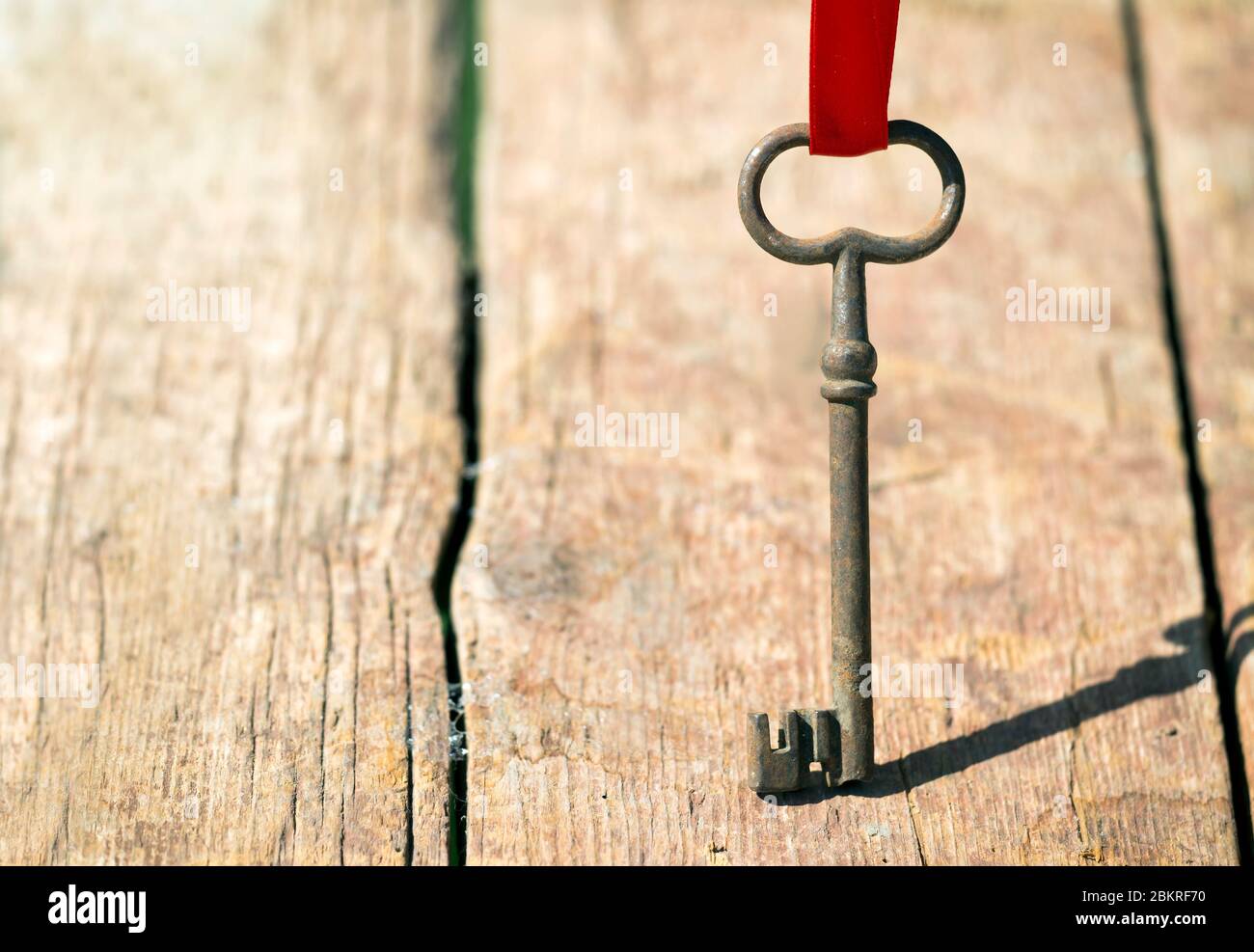 Old key standing on a wooden board - solution concept Stock Photo - Alamy