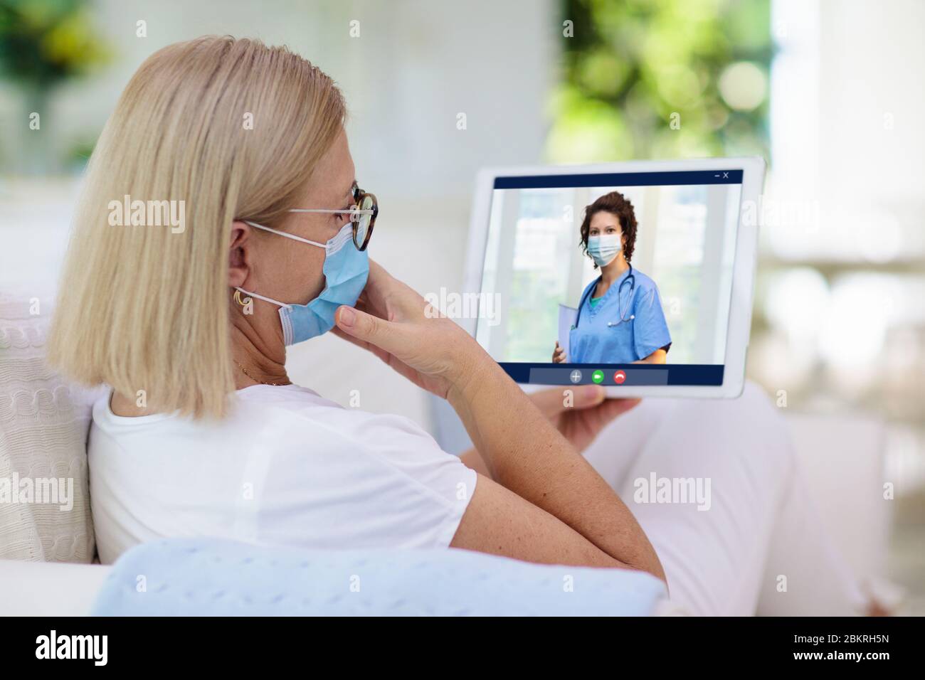 Sick woman in face mask calling doctor. Online video chat and ...