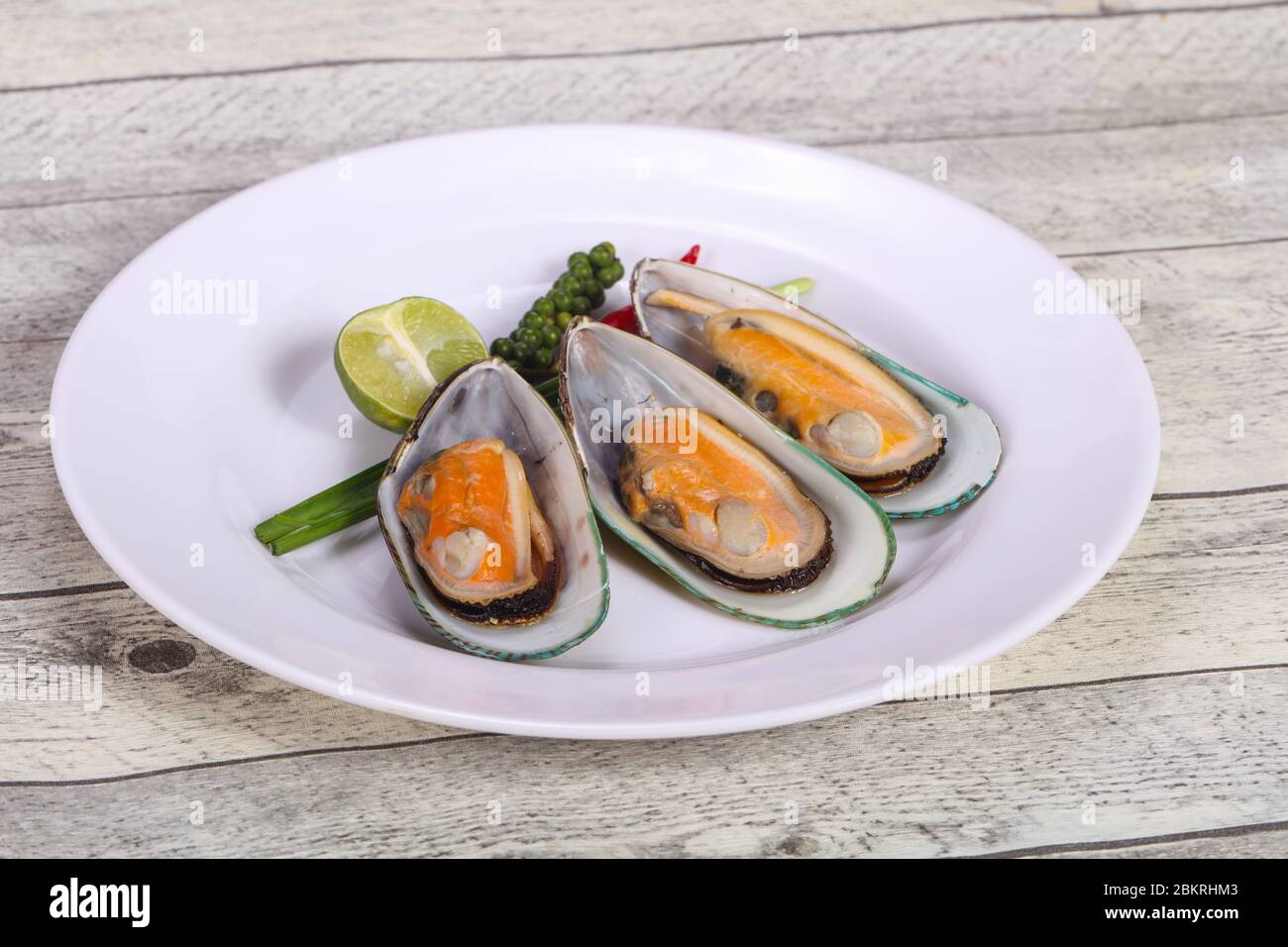 Half mussels with lime and green pepper Stock Photo - Alamy