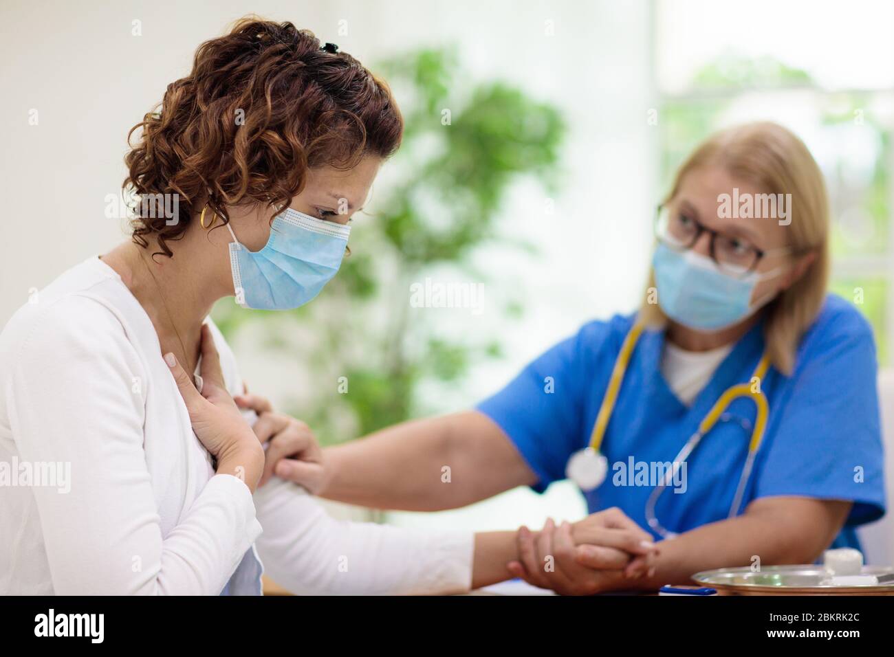 Doctor examining sick patient in face mask. Ill woman in health clinic ...