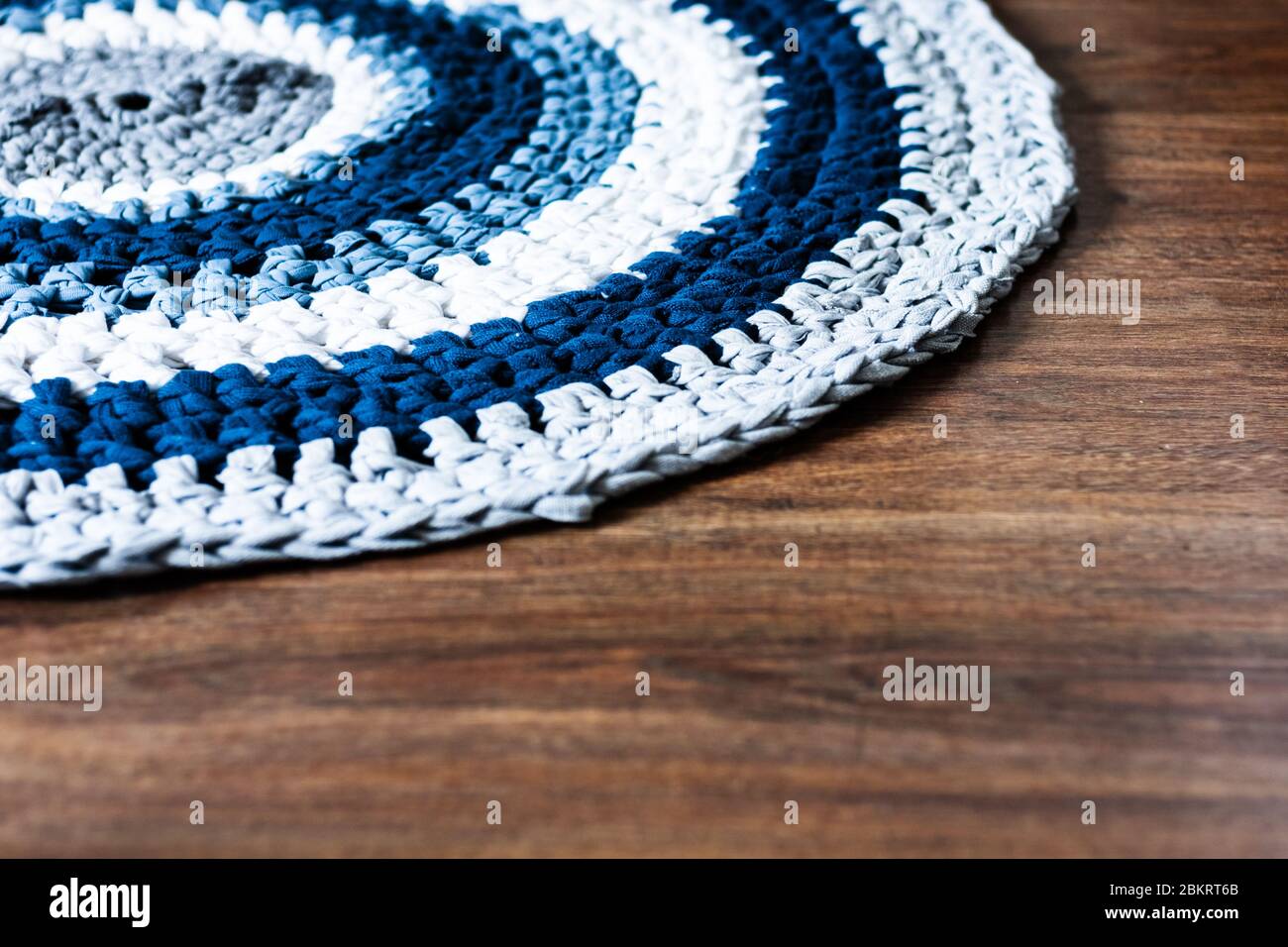 handmade round wicker rug on a wooden floor, cozy home interior decor ...