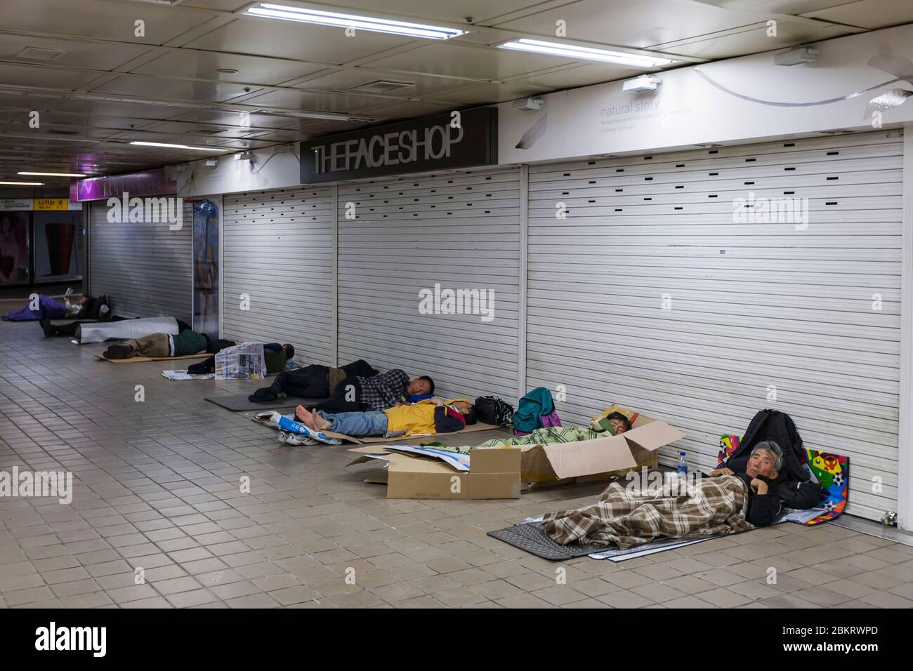 South Korea, Seoul, Myeongdong district, homeless men sleeping in front ...