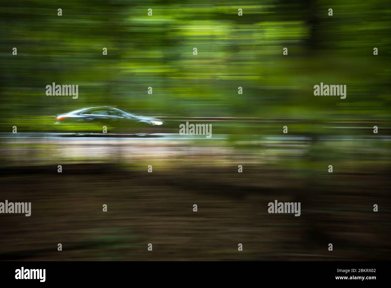 Cars going fast on an interstate road amid forests Stock Photo - Alamy