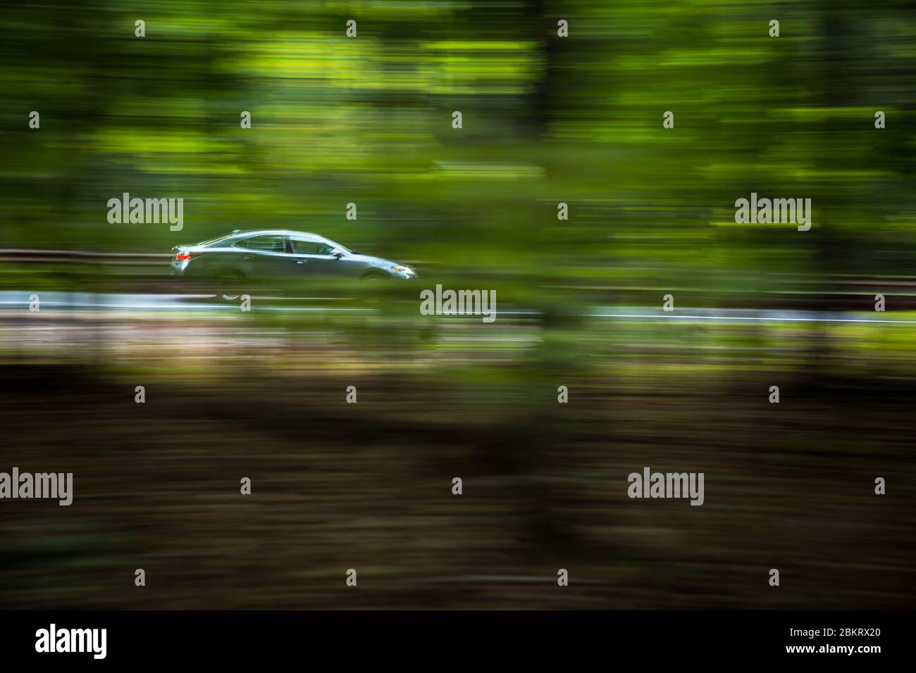 Cars going fast on an interstate road amid forests Stock Photo - Alamy