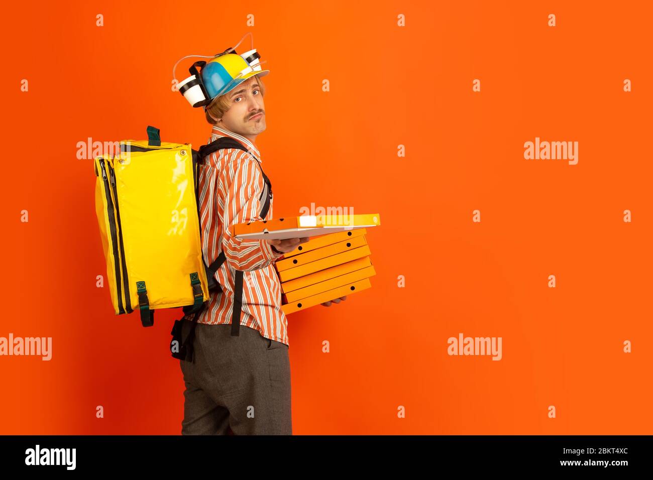 Sad, tired holding pizza boxes. Emotions of caucasian deliveryman ...