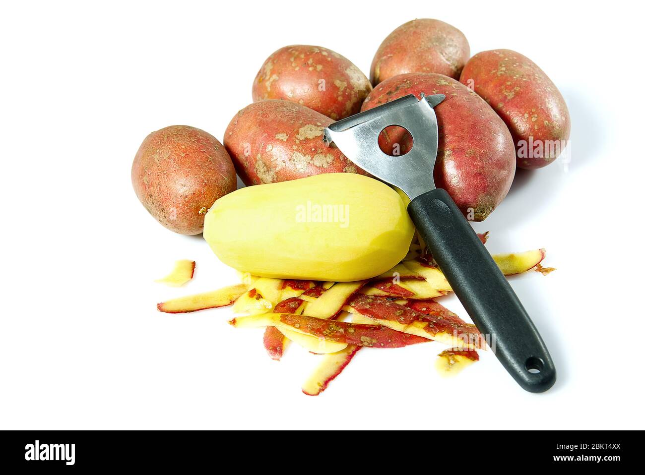 a pile of unpeeled potatoes and black potatoes peeling, white ...
