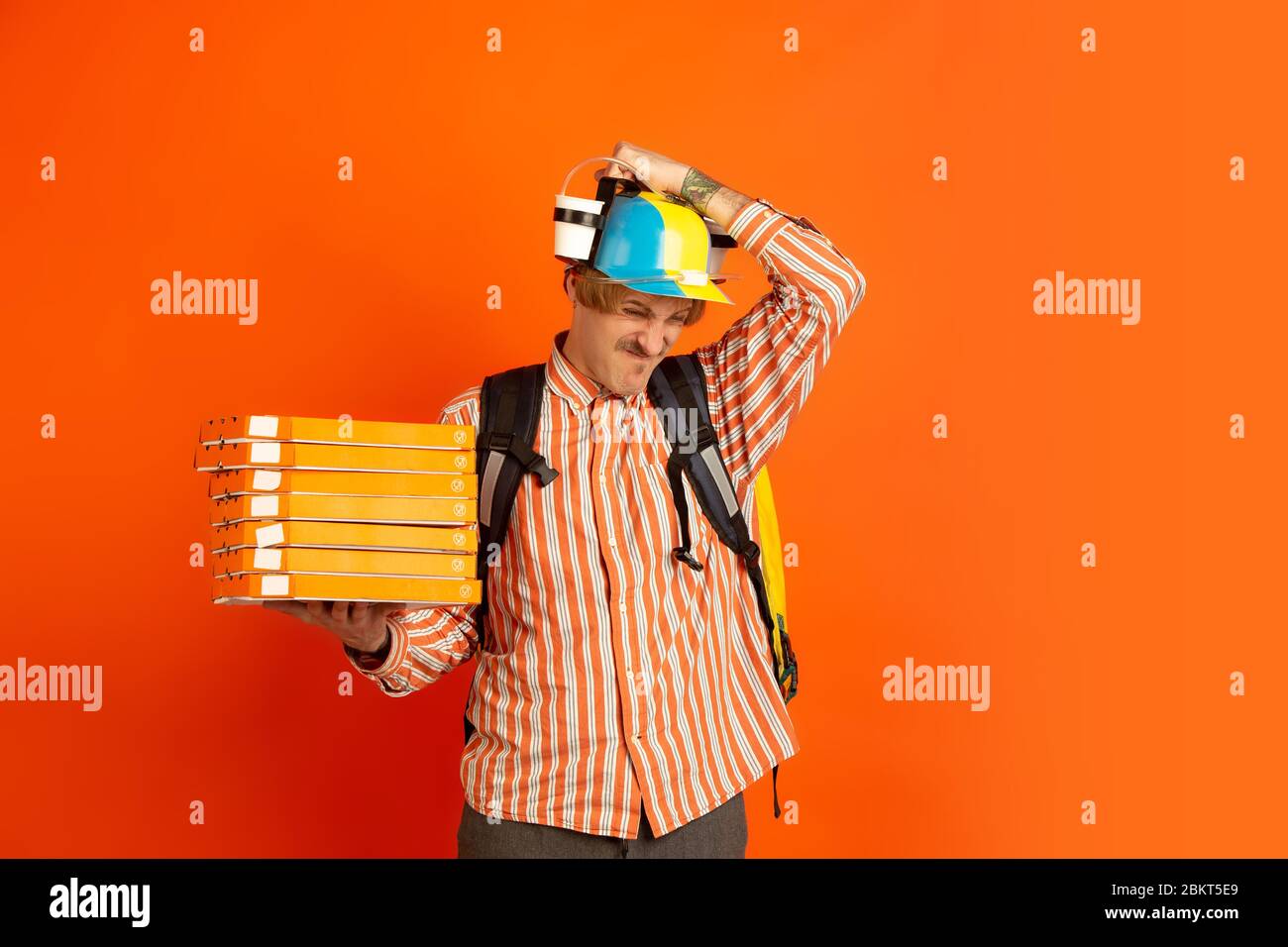 Sad, tired holding pizza boxes. Emotions of caucasian deliveryman ...