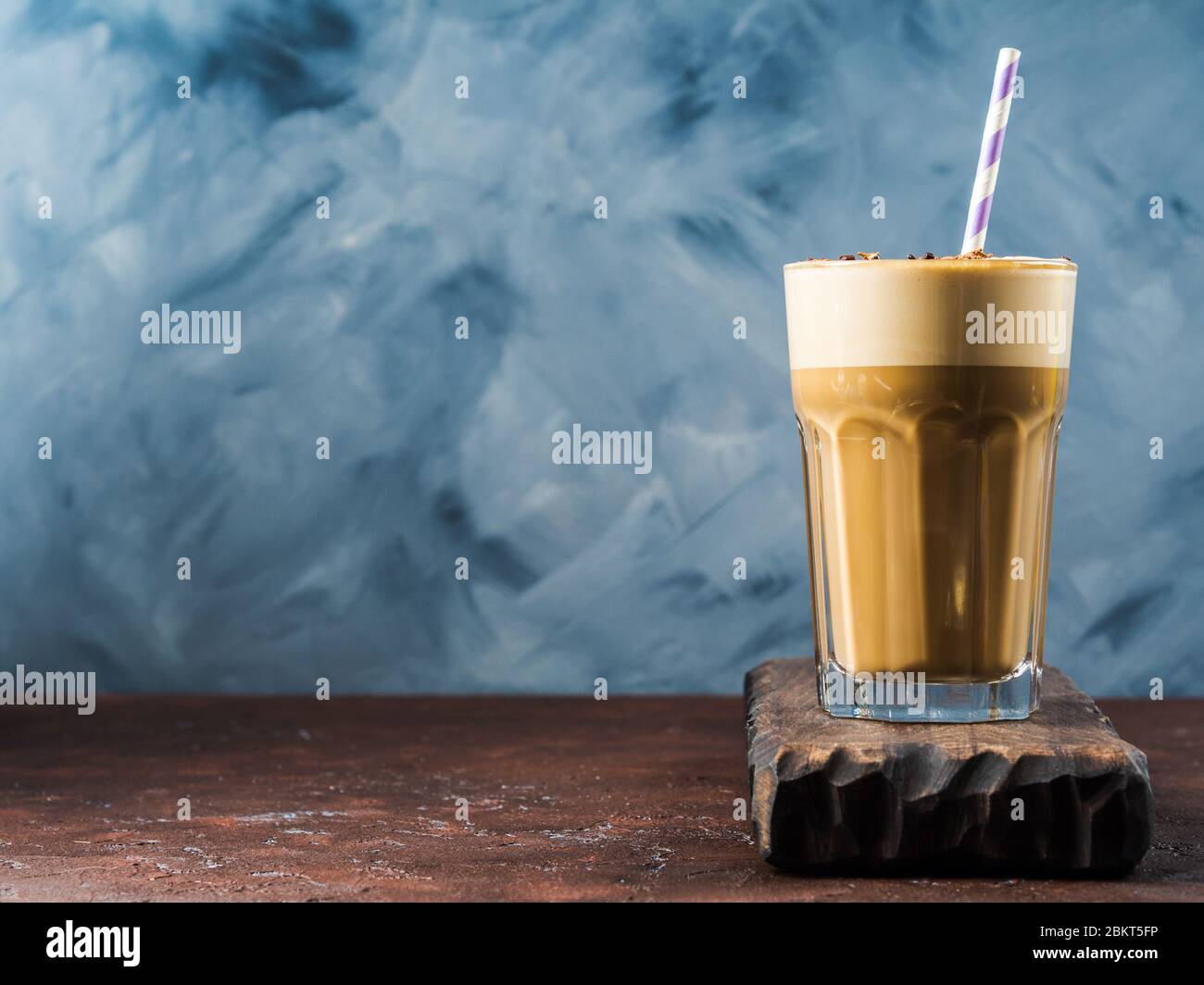 Frappe coffee in tall glass on blue and brown Stock Photo - Alamy