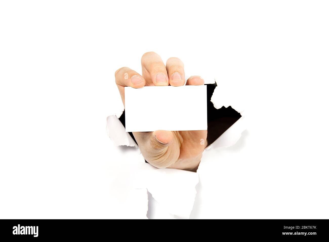 man hand holding white business card thru hole in wall or broken white ...