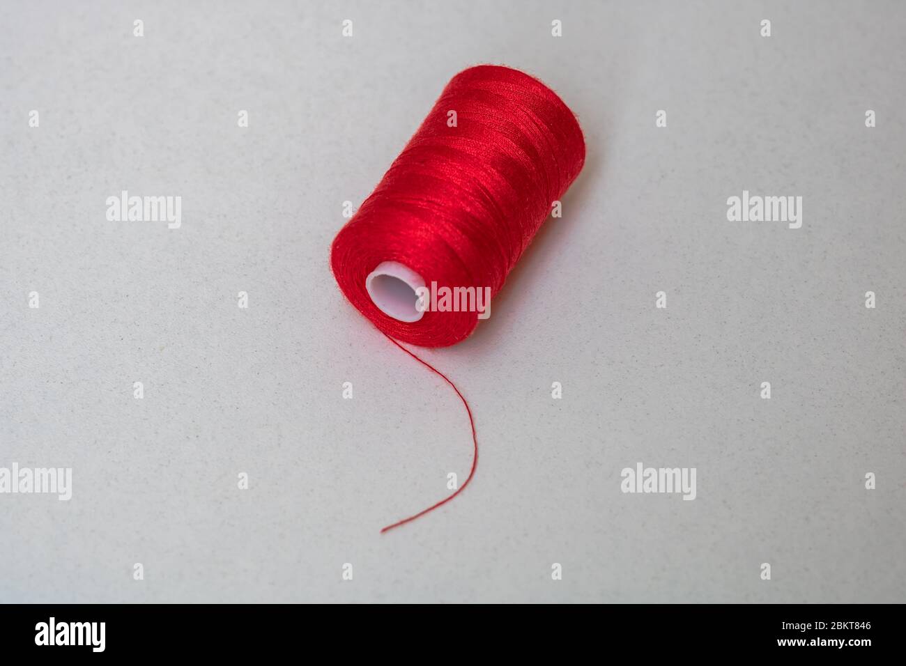 Red spool of sewing thread isolated, close up Stock Photo - Alamy
