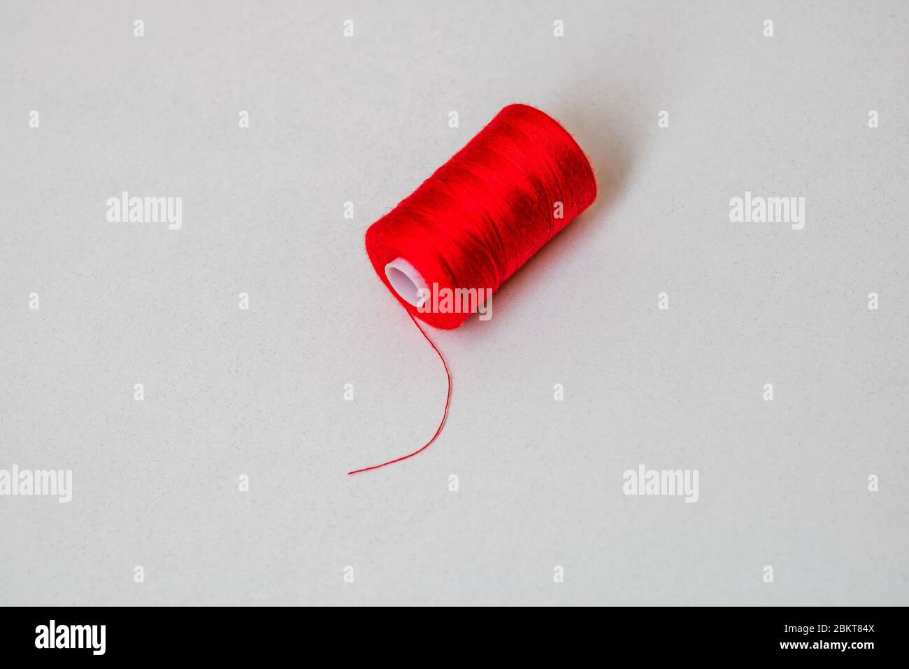 Red spool of sewing thread isolated, close up Stock Photo - Alamy