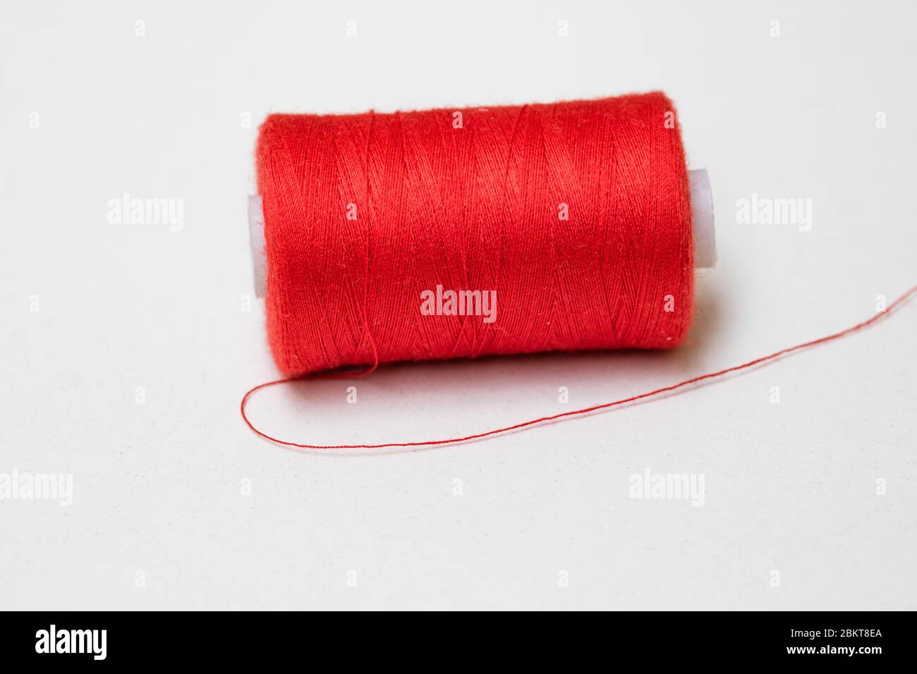 Red spool of sewing thread isolated, close up Stock Photo - Alamy