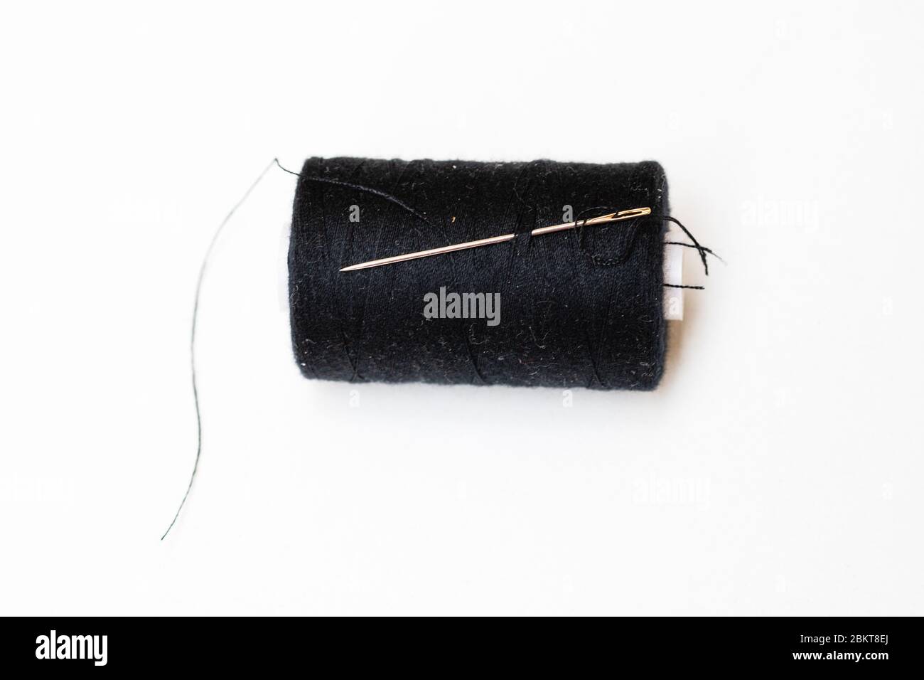 Black spool of sewing threads isolated on blurred background Stock ...