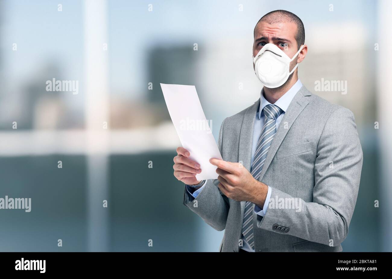 Worried masked businessman holding a document during coronavirus ...