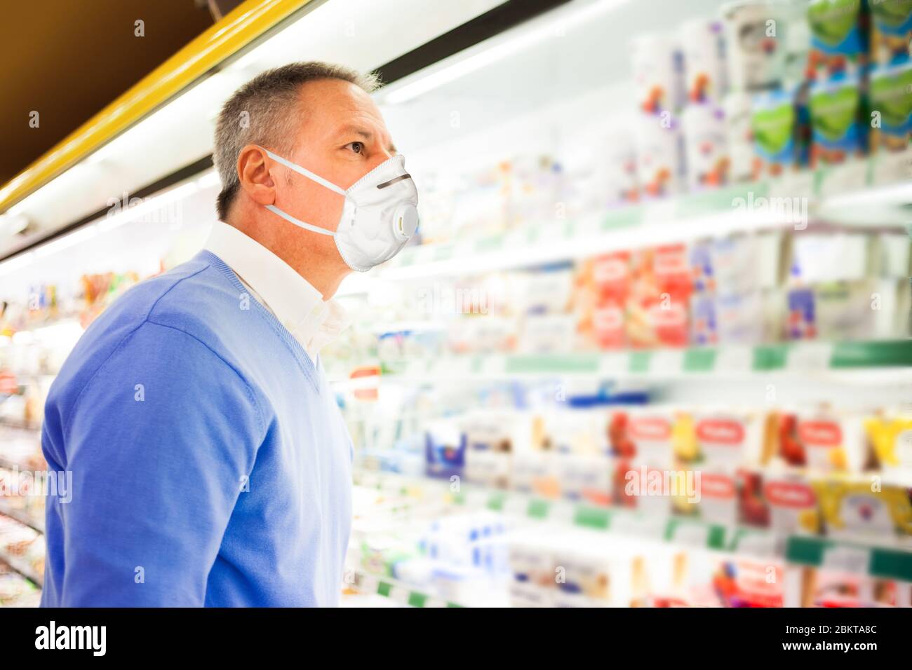 Man looking at a product in a supermarket Stock Photo - Alamy