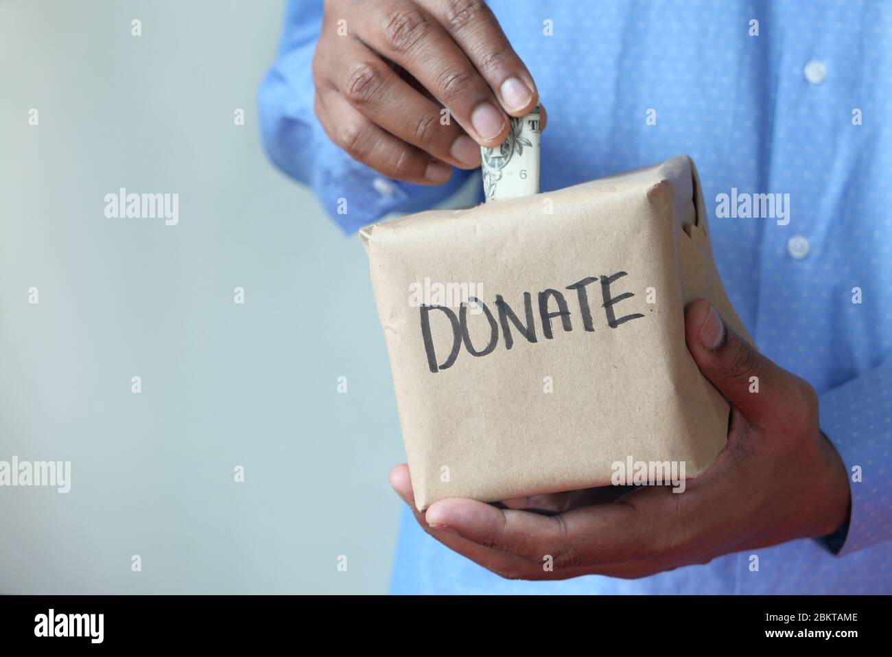 Man puts donation in a box with copy space Stock Photo - Alamy