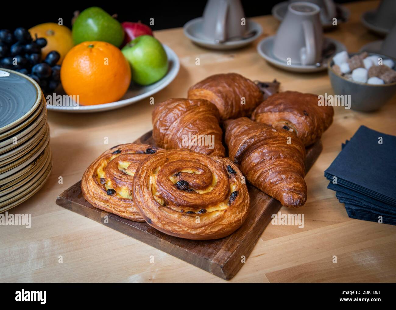 A Breakfast meeting buffet, with cinnamon rolls, croissants and fruit ...