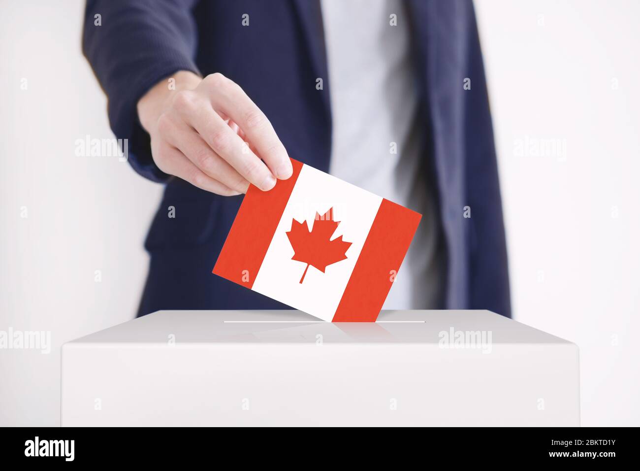 Man putting a ballot with Canadian flag into a voting box Stock Photo ...