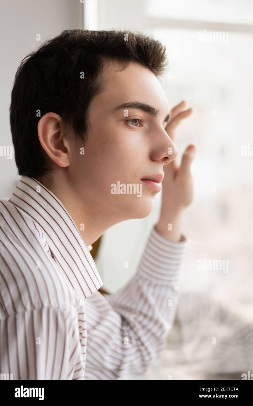 Teen boy looking out window hi-res stock photography and images - Alamy