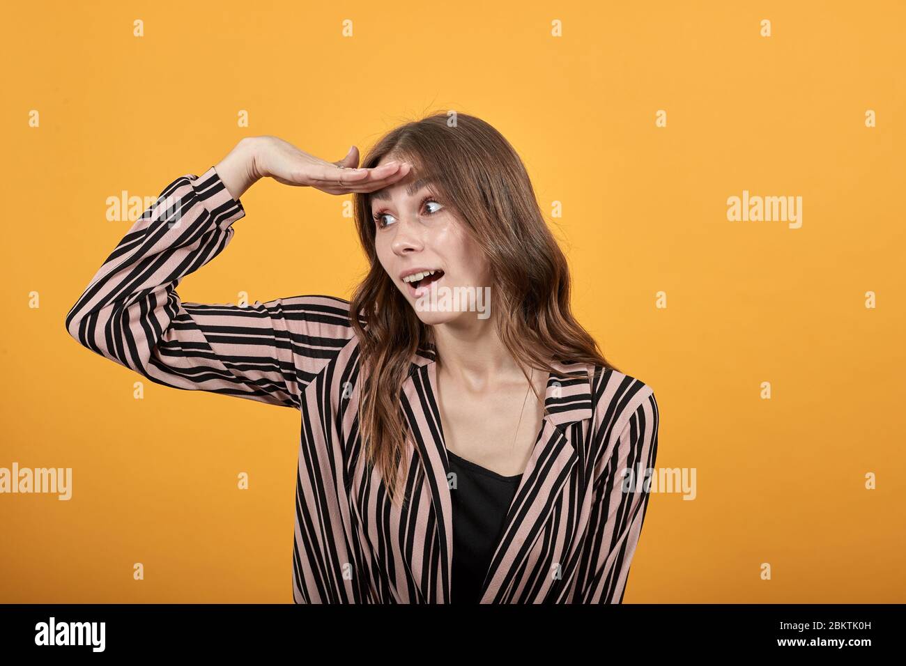 Happy Girl With Interest Looks Into The Distance, Holds Hand Over Her ...