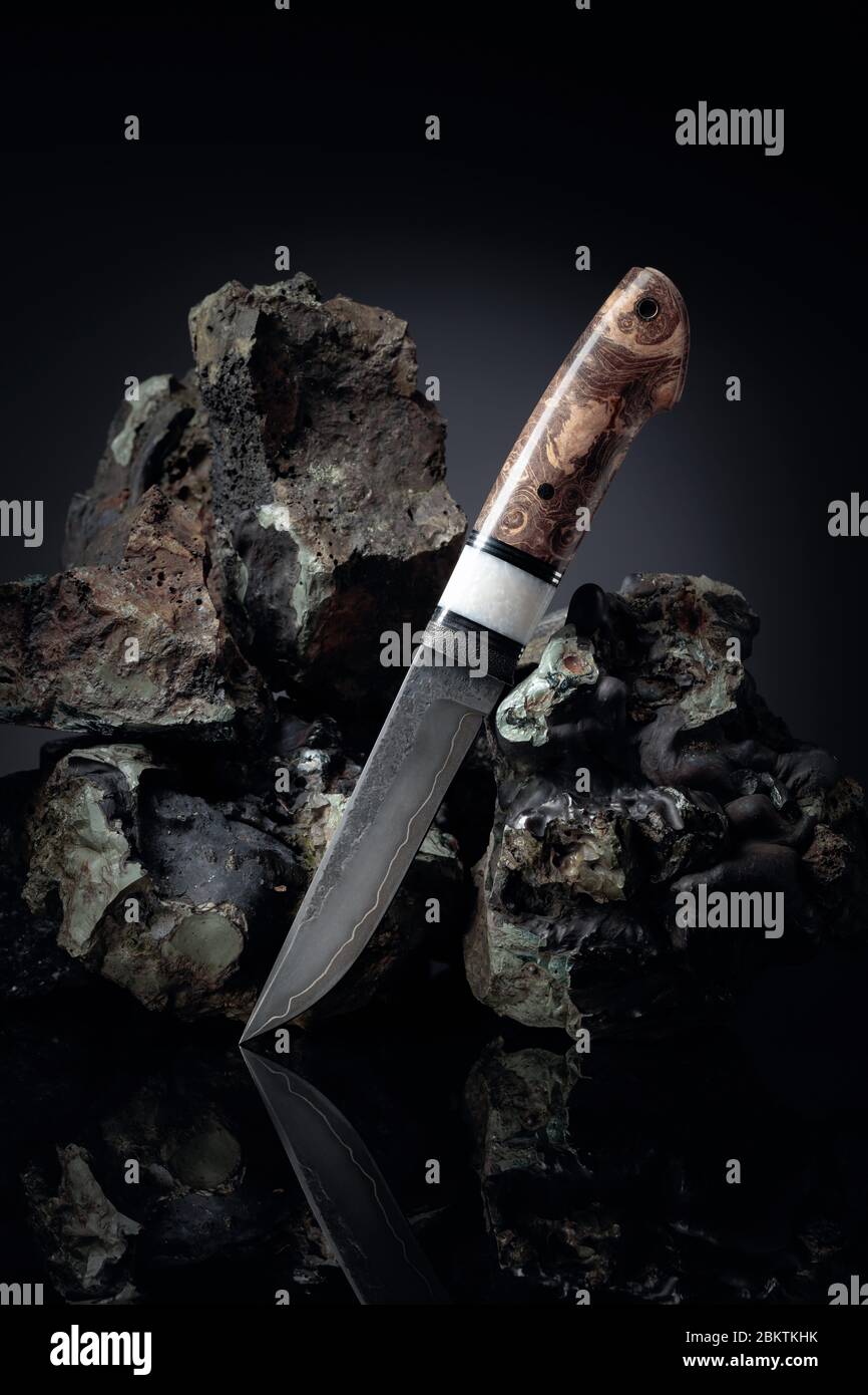Hunter hand made knife and broken stones. The surface of the blade ...
