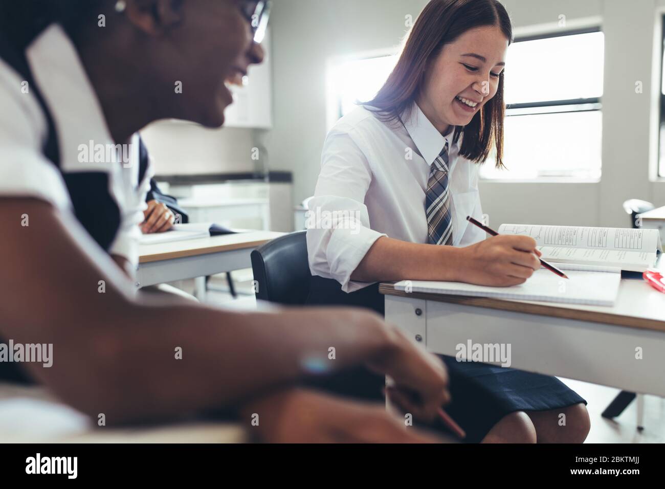 Female students in classroom smiling while studying. High school girls ...