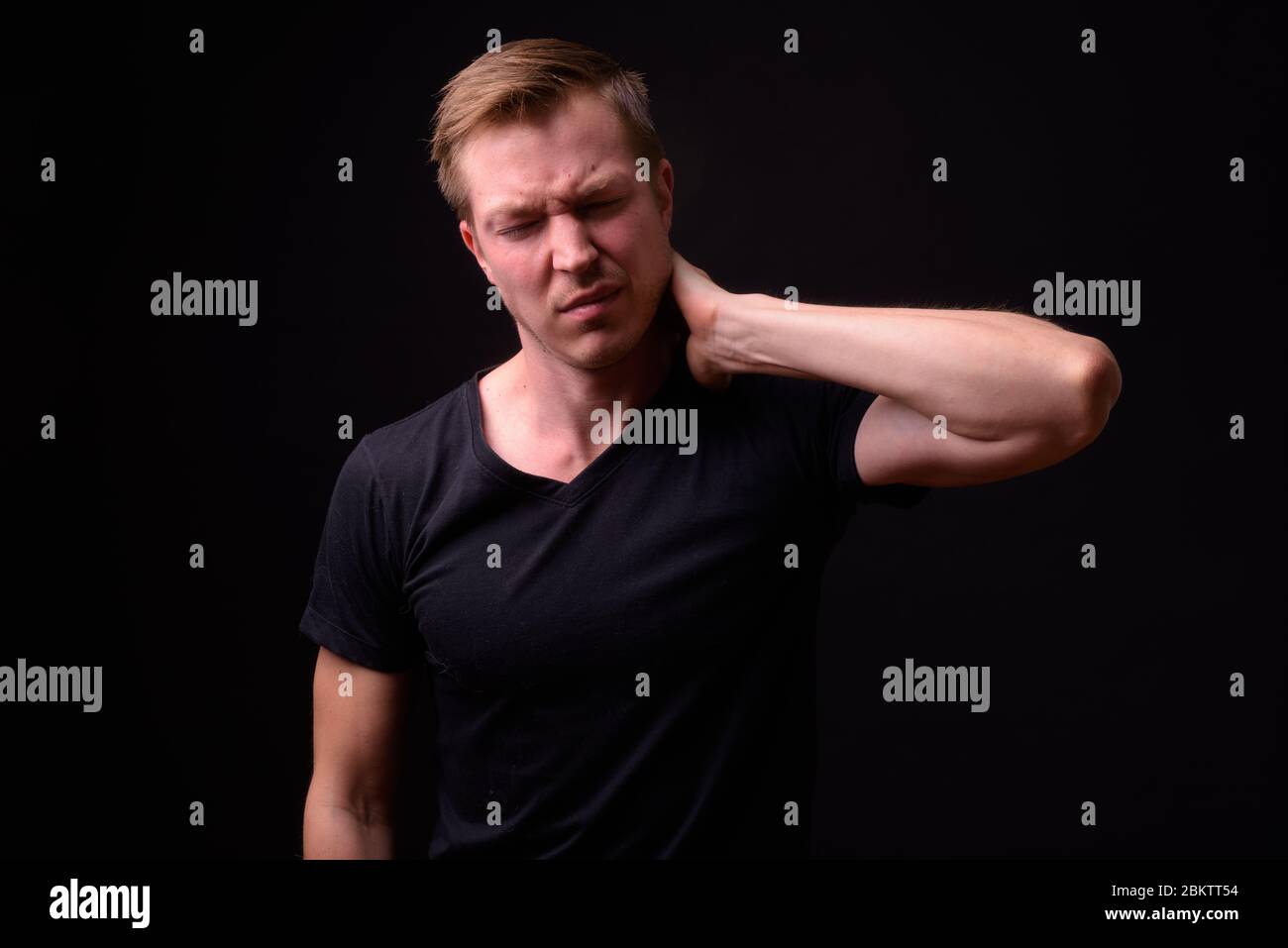 Portrait of stressed young man having neck pain Stock Photo - Alamy