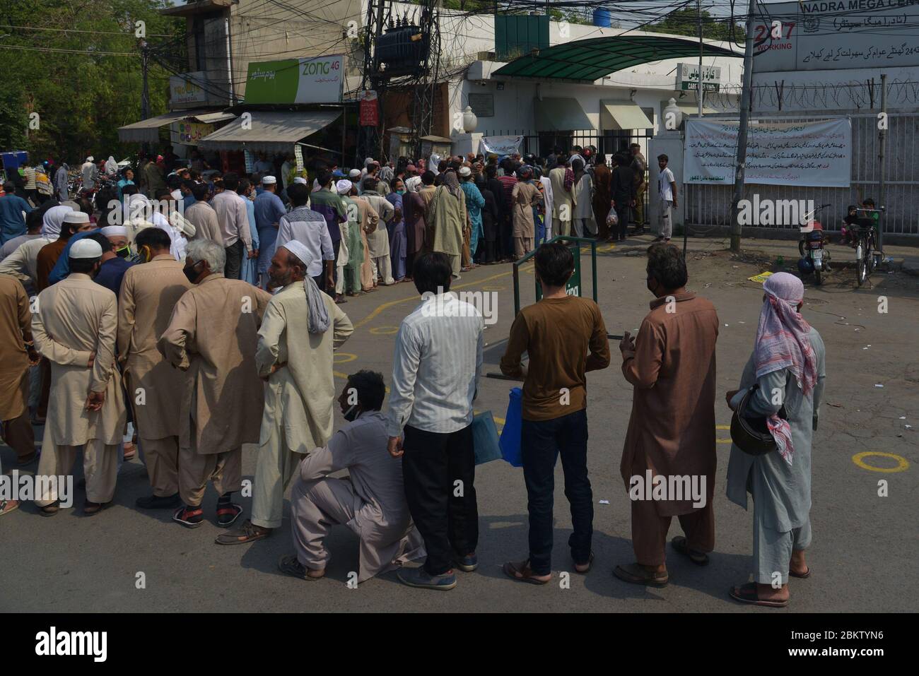 A large numbers of people stand in queue without maintaining social ...