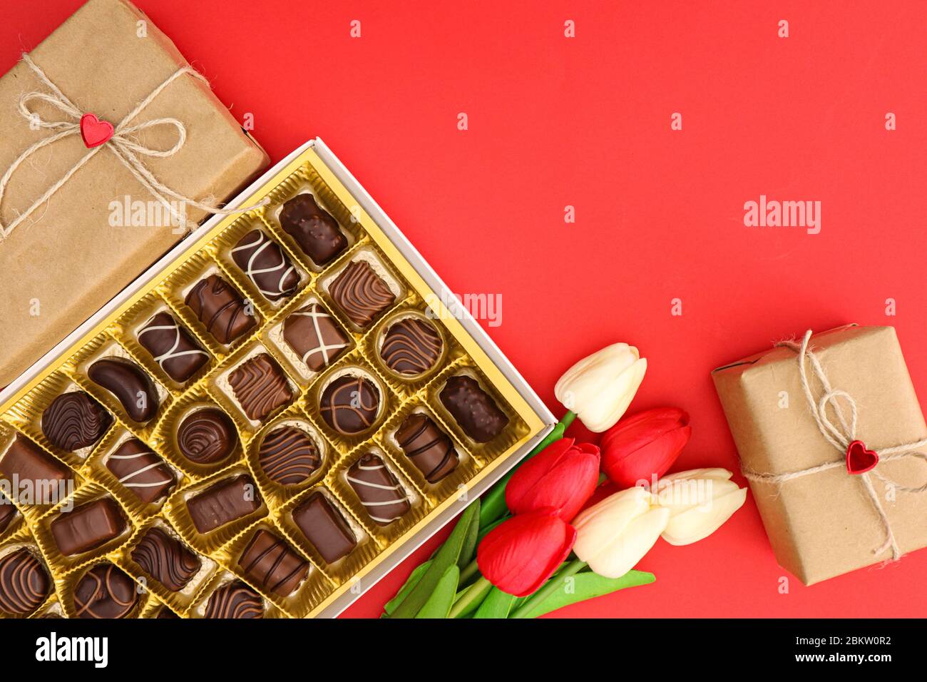 Beautiful chocolates for special day with gifts and tulips Stock Photo ...