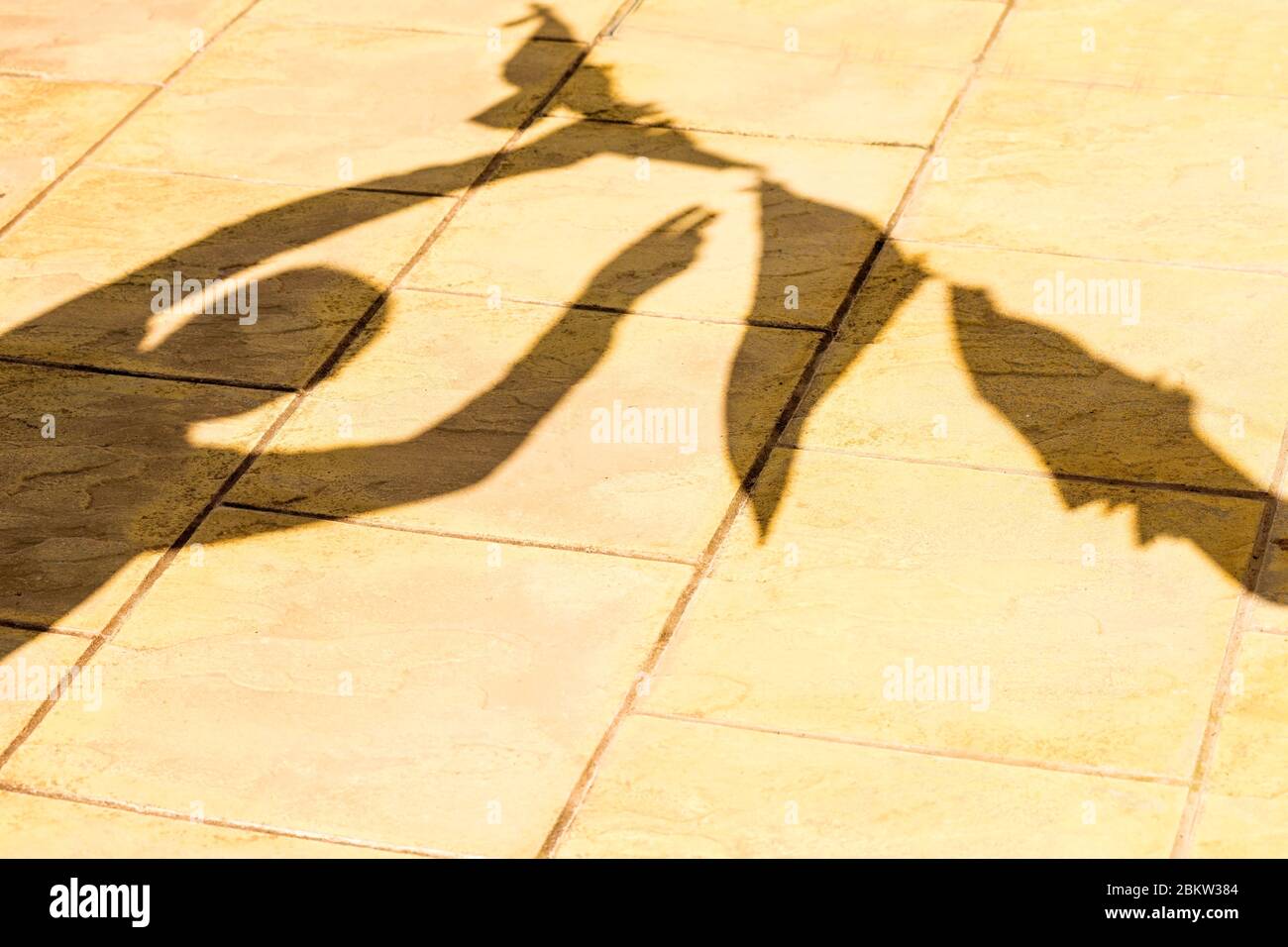 Sunlight shadow of man hang the clothes washing line at the garden ...