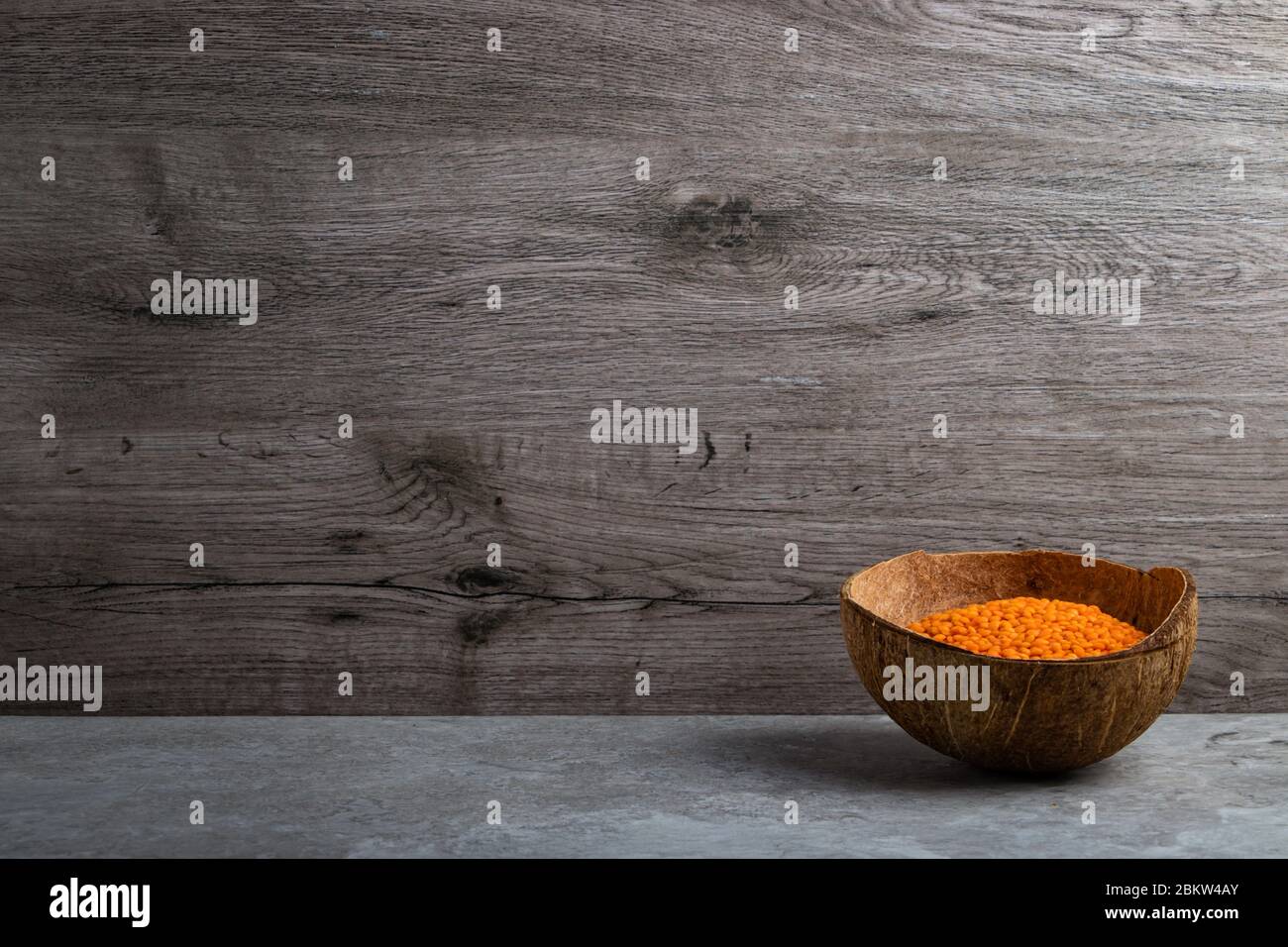 Red lentils in coconut shell on tile background Stock Photo - Alamy
