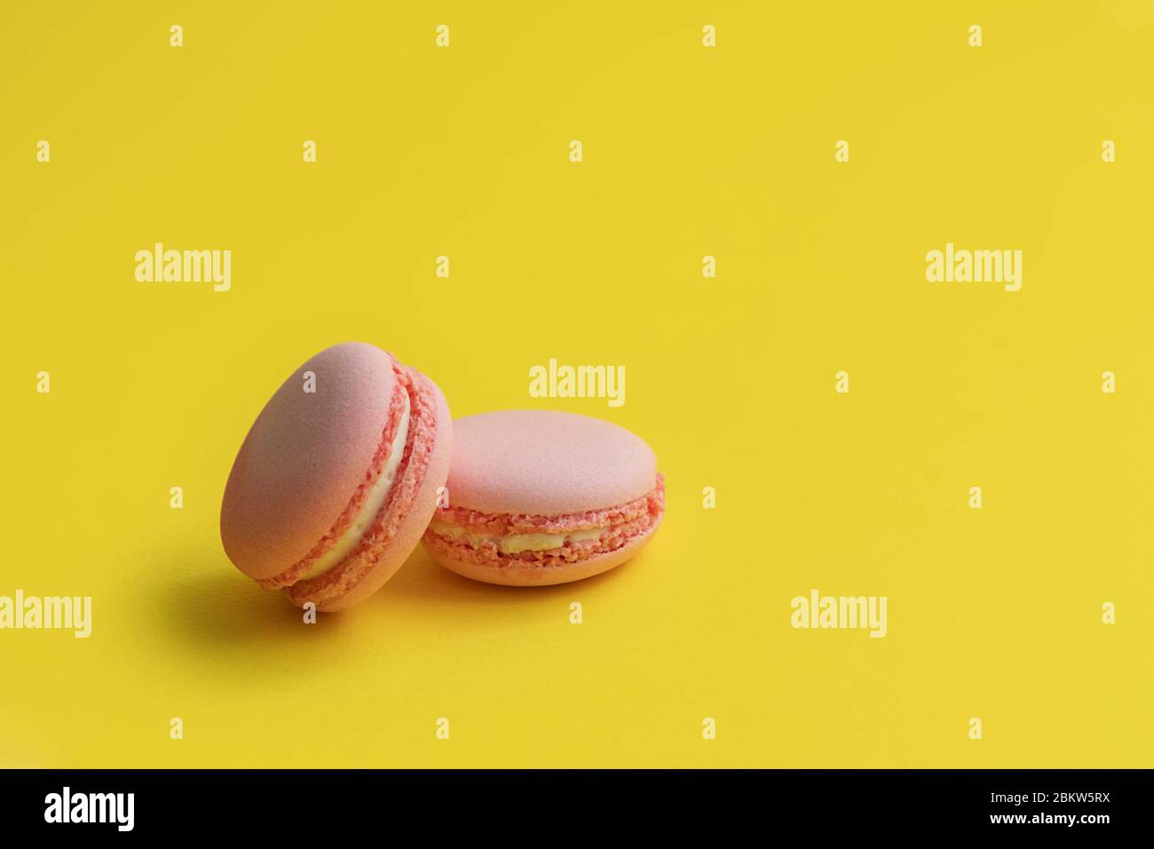 Pink macaroons. Sweet macarons on yellow background with copy space ...