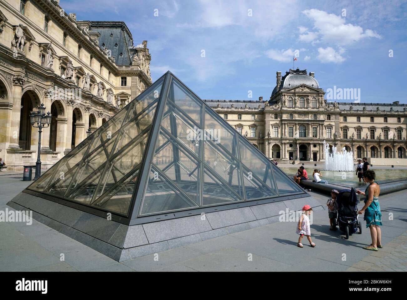 Visitors by the one of the small glass pyramids designed by I.M.Pei in ...