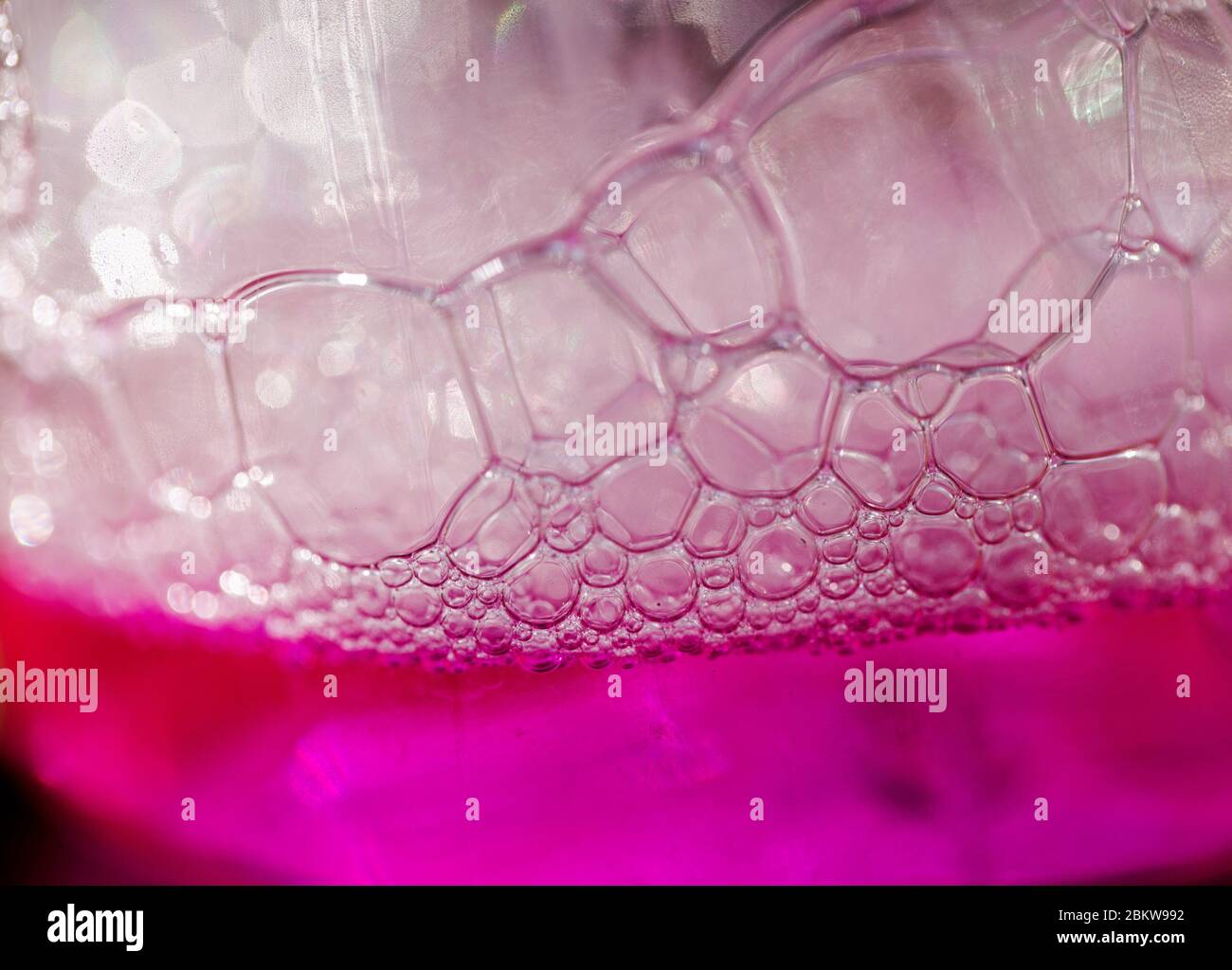 Pink liquid with foam bubbles on top shot close up in landscape format ...