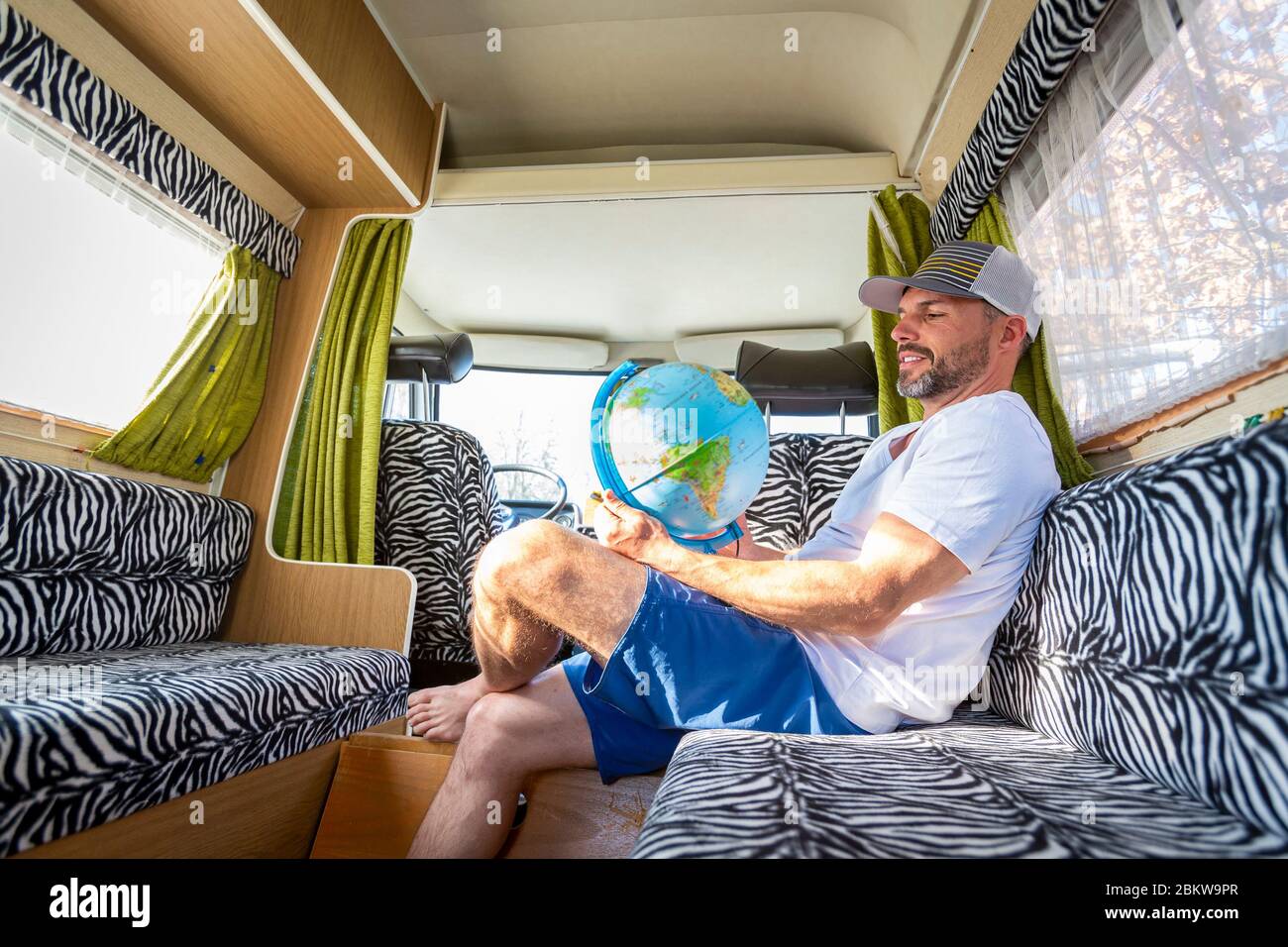 Portrait of careless man during holidays sitting in his van looking at ...