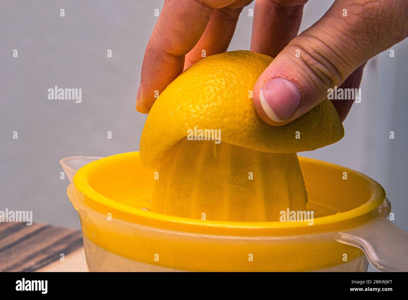 A half of yellow lemon squeezed on the plastic yellow juicer in the ...