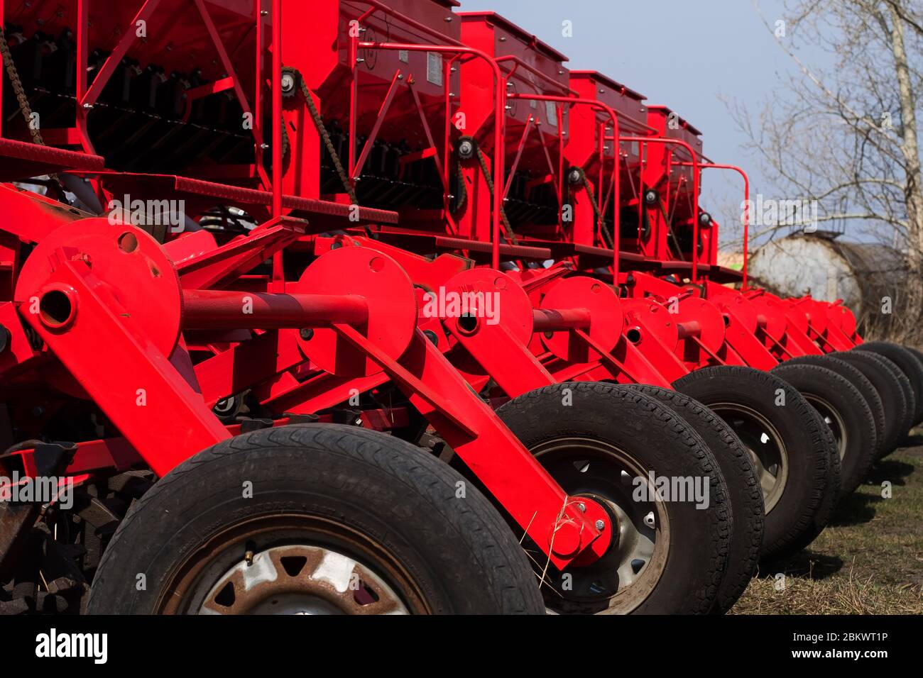 Modern sowing seeds machine. Farmer tractor seeding. Red combine plow ...