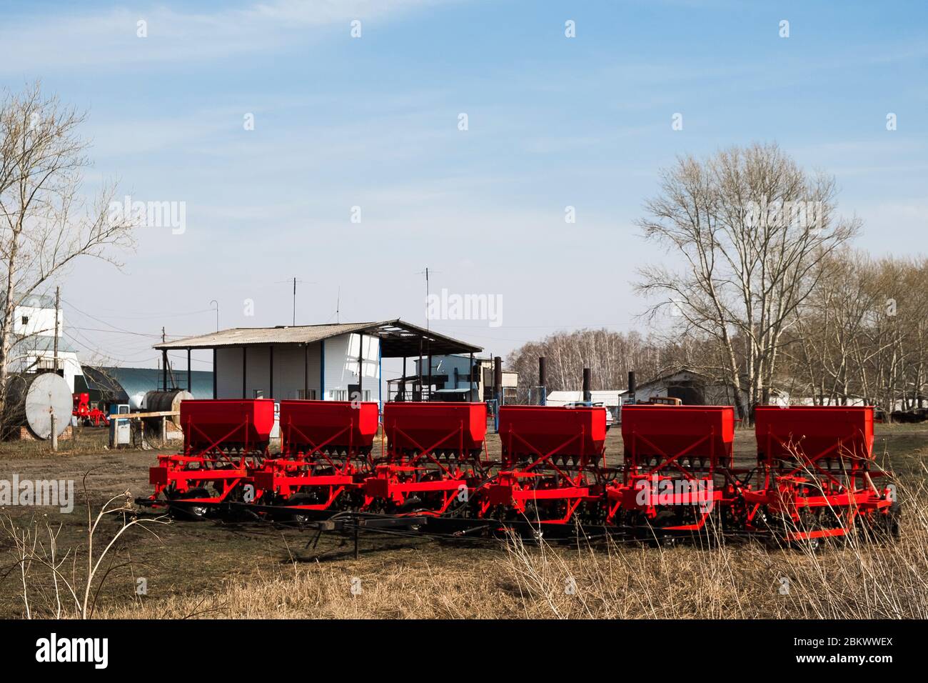 Modern sowing seeds machine. Farmer tractor seeding. Red combine plow ...