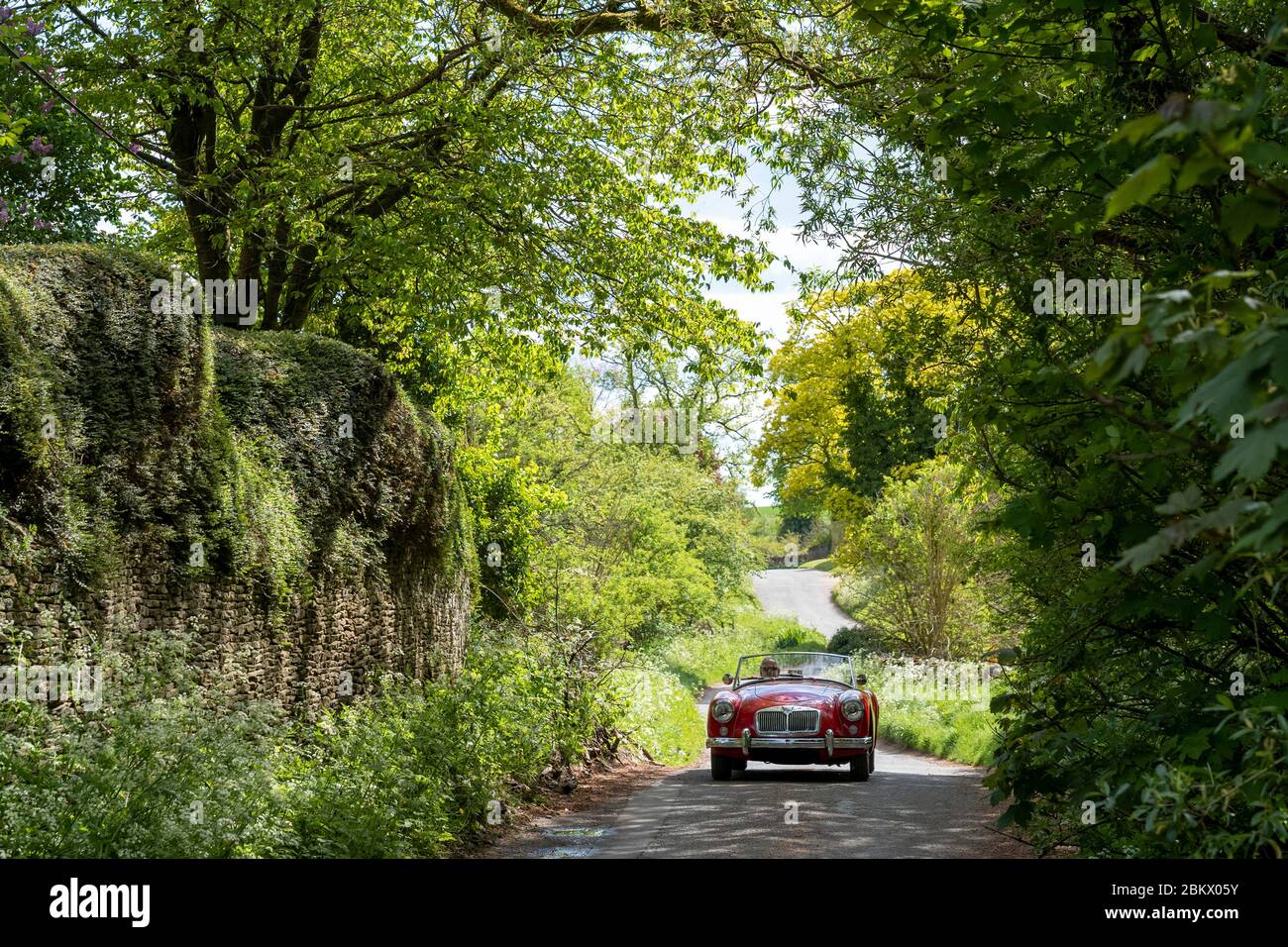 Man driving open top convertible MG sports car in The Cotswolds, UK ...