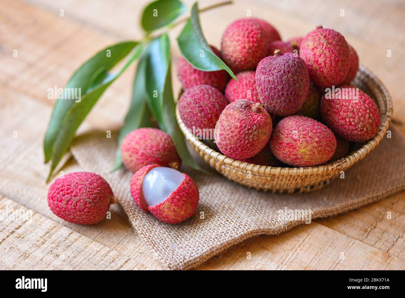 Lychee slice peeled on wooden / Fresh lychee with green leaves harvest ...
