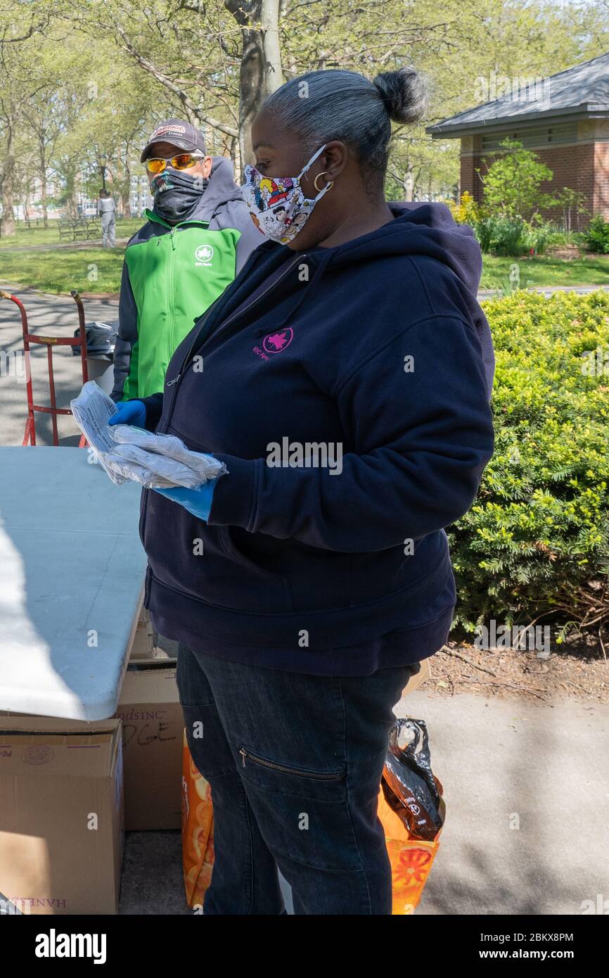 NEW YORK, NY - MAY 5, 2020: A volunteer hands out free face masks from ...