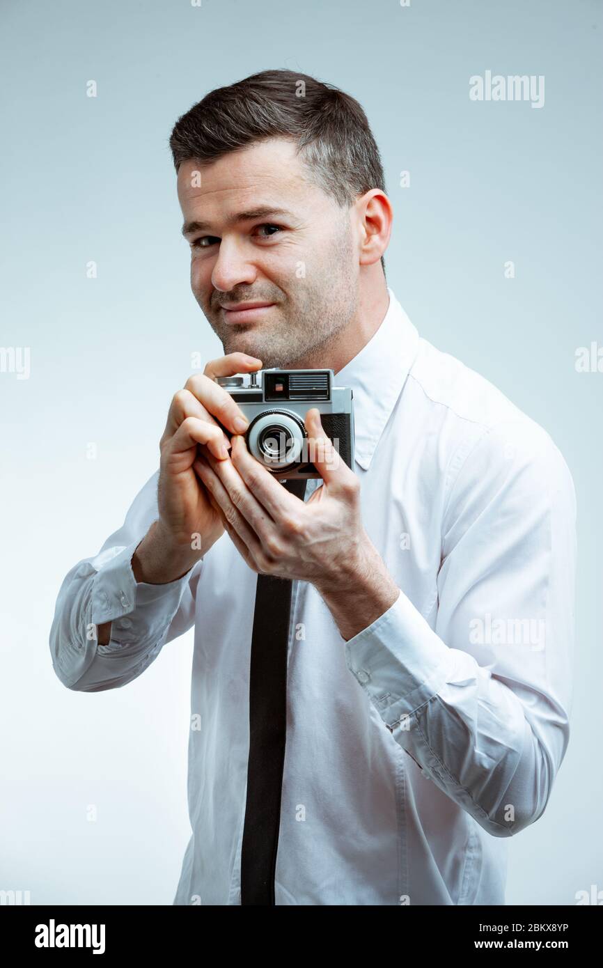 Smiling handsome young man in white shirt and black necktie looking ...