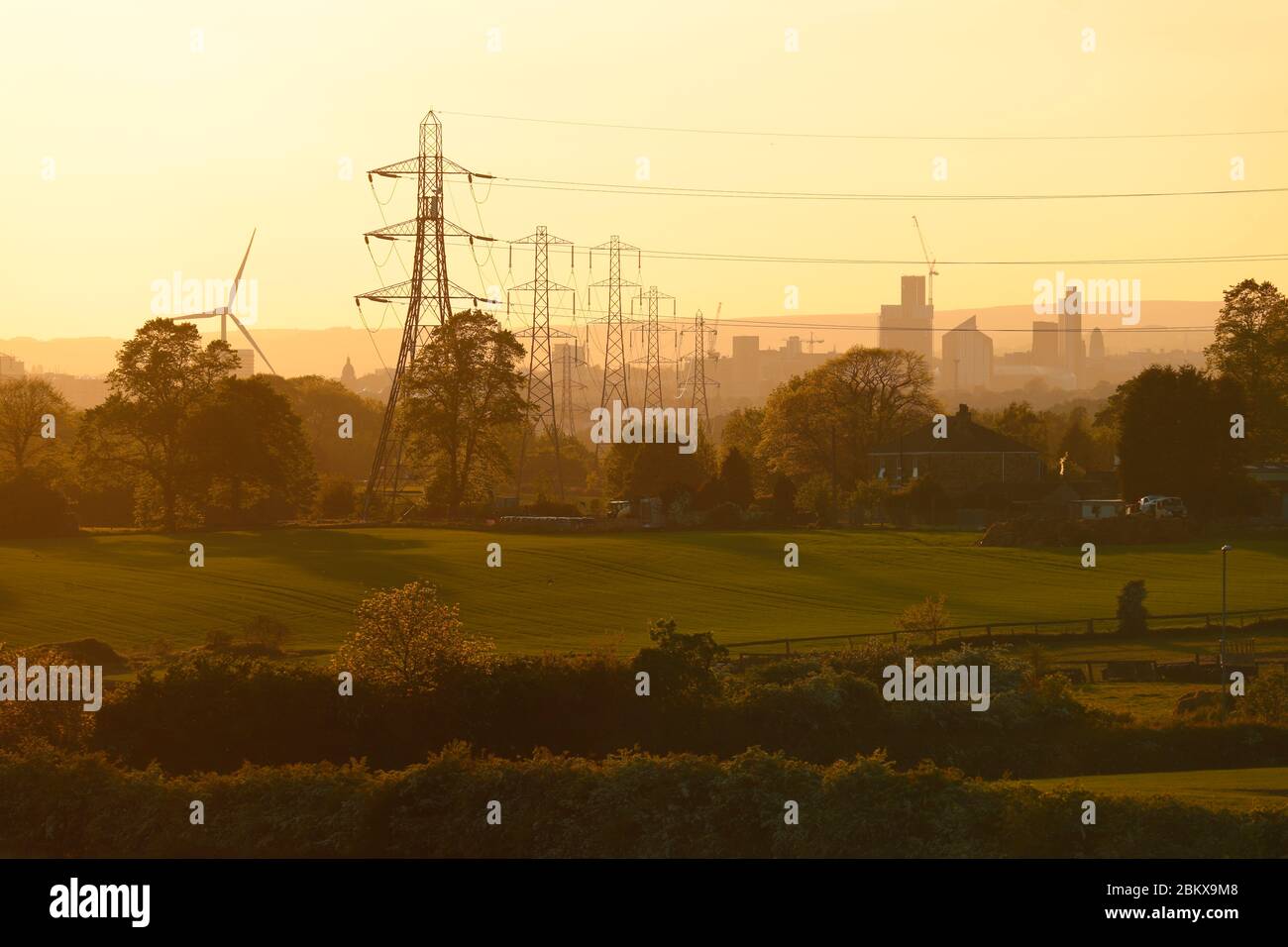 Sunset behind Leeds skyline with pylons from the National Grid at ...