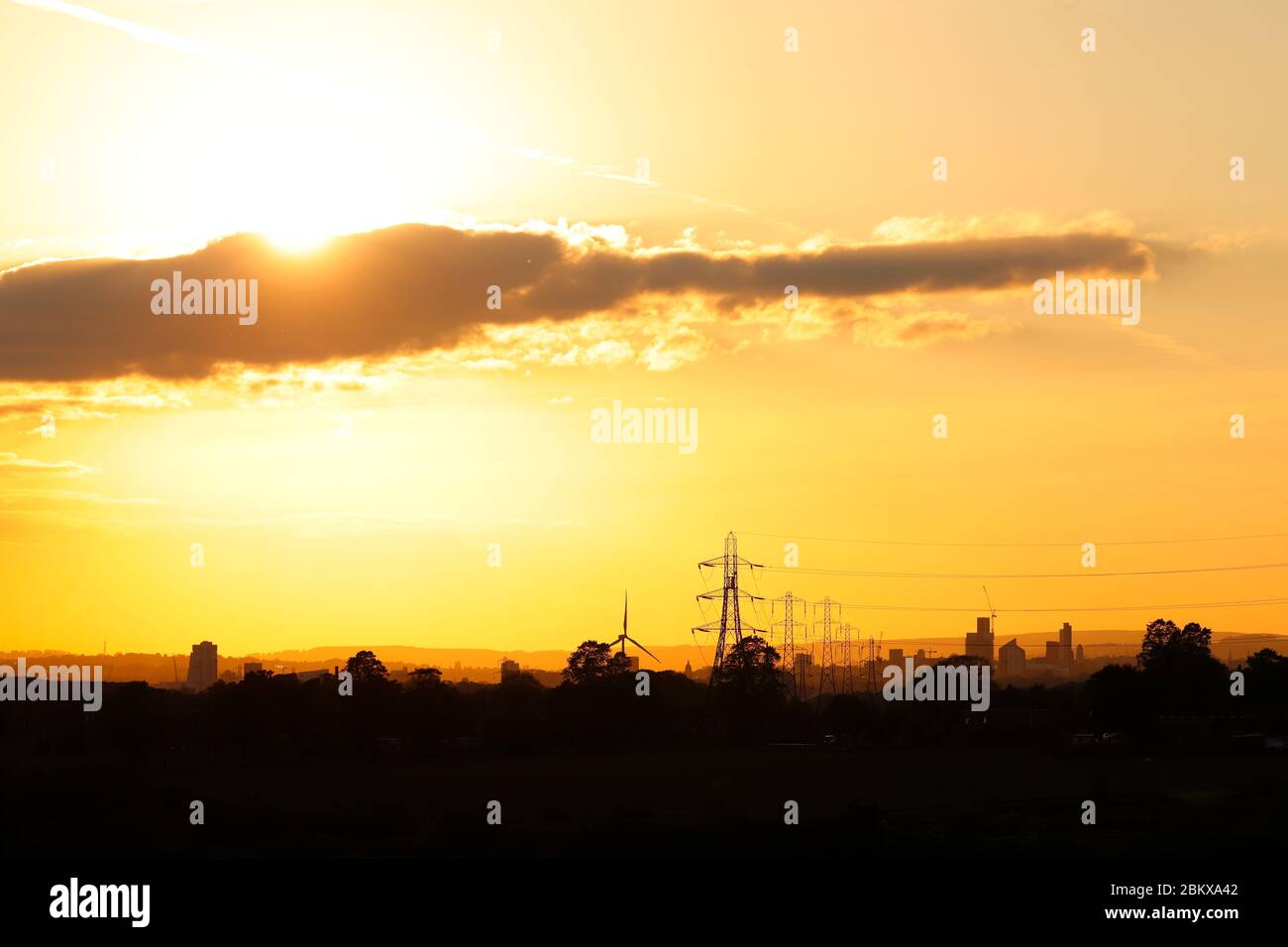 Sunset behind Leeds skyline with pylons from the National Grid at ...