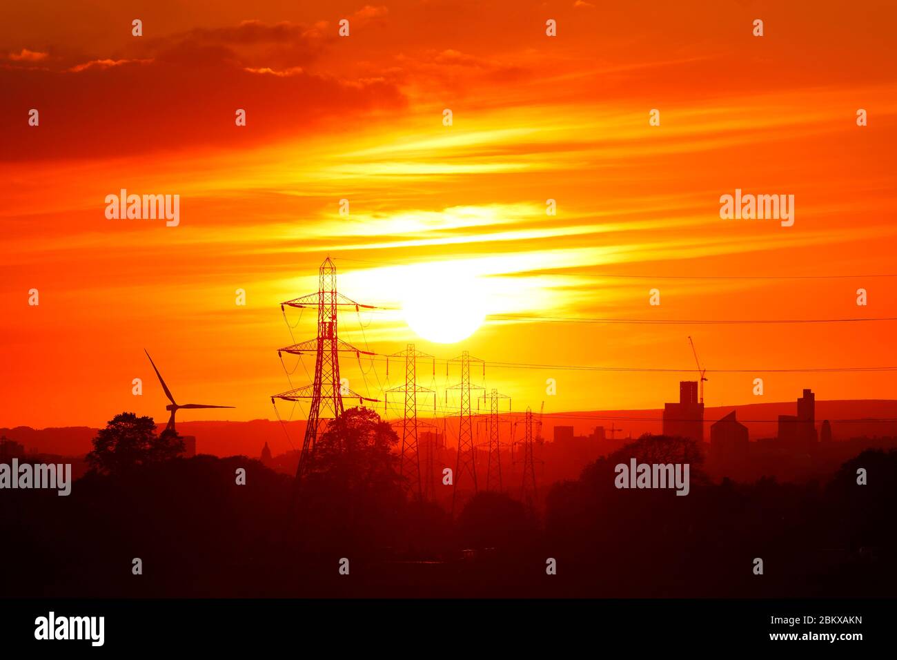Sunset behind Leeds skyline with pylons from the National Grid at ...